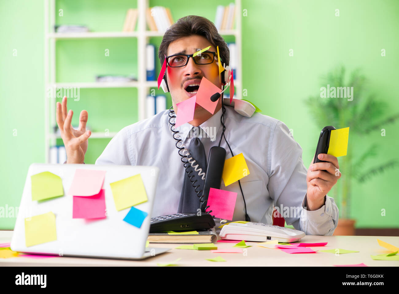 Young help desk operator working in office with many conflicting Stock ...