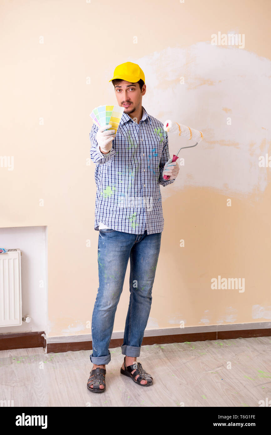 Painter man painting the wall at home Stock Photo - Alamy