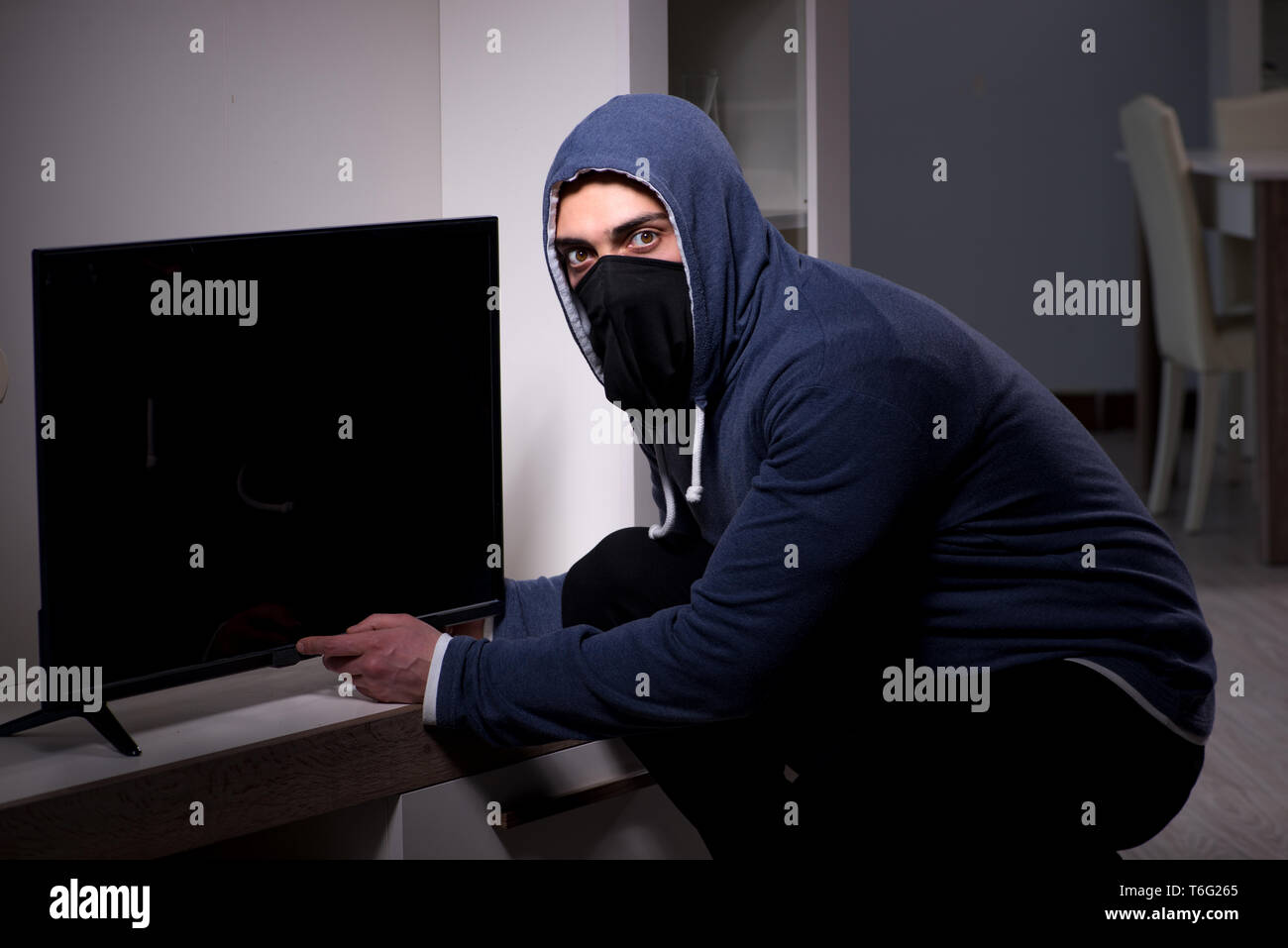 Burglar thief stealing tv from apartment house Stock Photo - Alamy