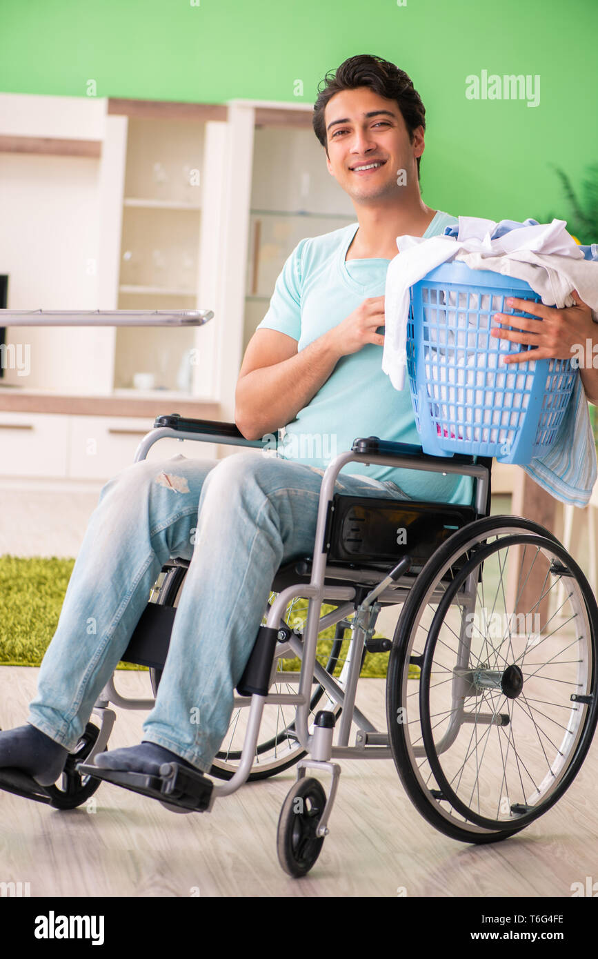Disabled man on wheelchair doing laundry Stock Photo - Alamy