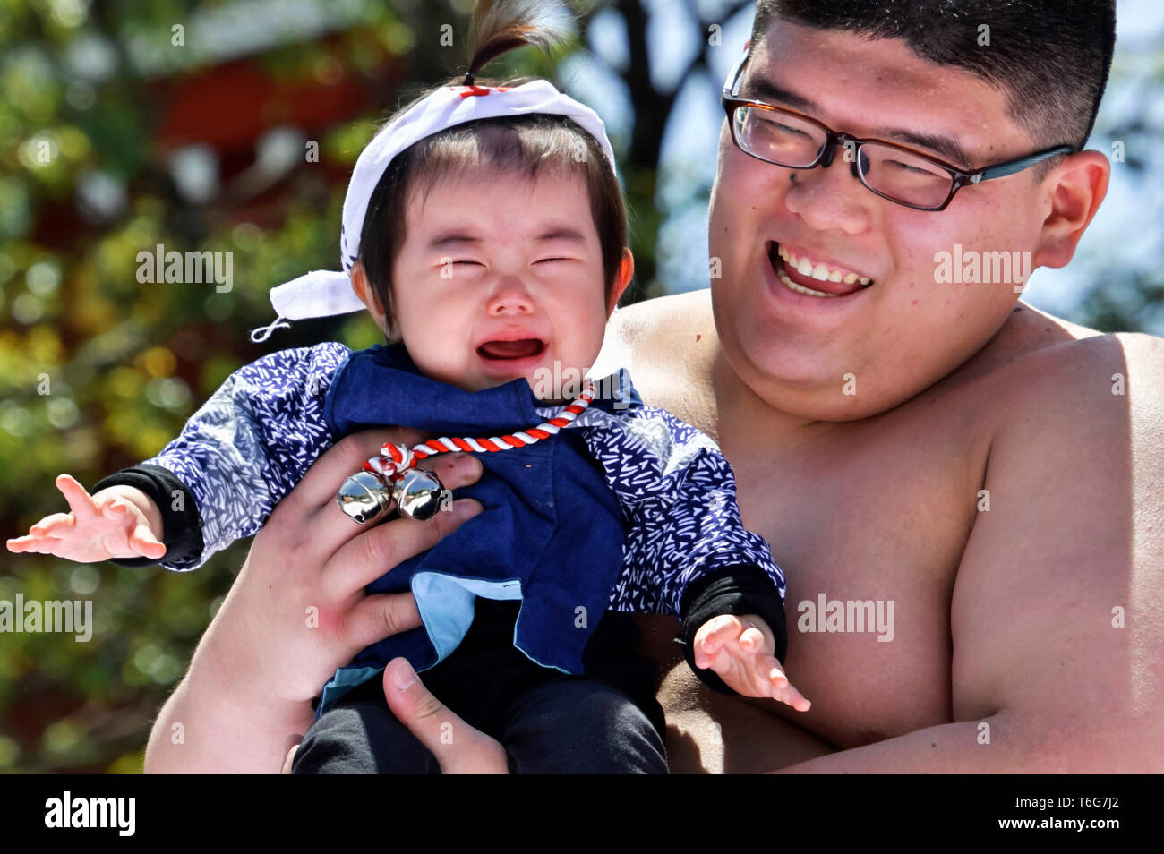 Sumo wrestlers hold up crying babies during a "Baby-cry Sumo" event at ...