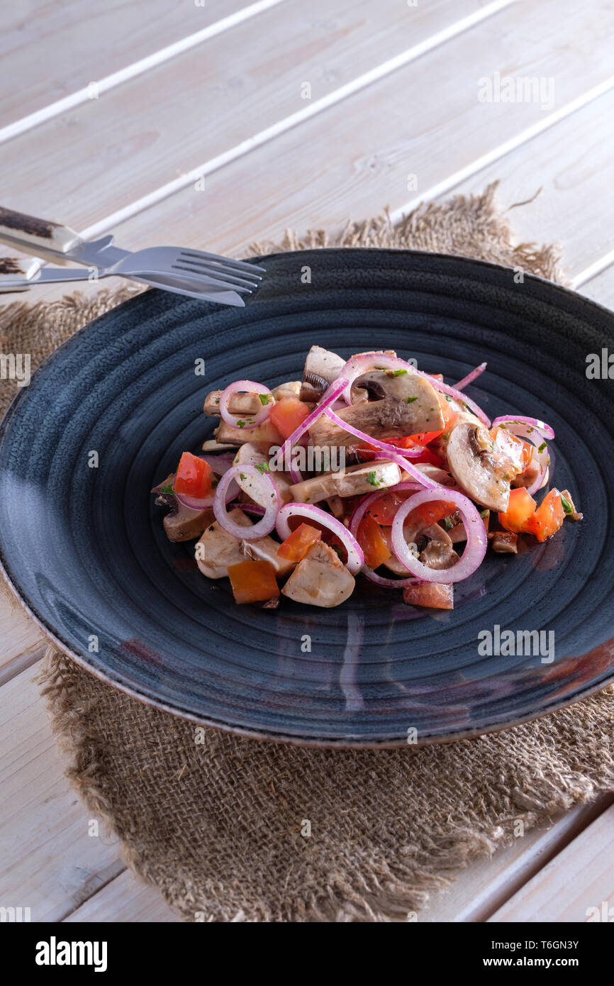 Lightly fried champignon with fresh onion rings and tomato. Snack for ...
