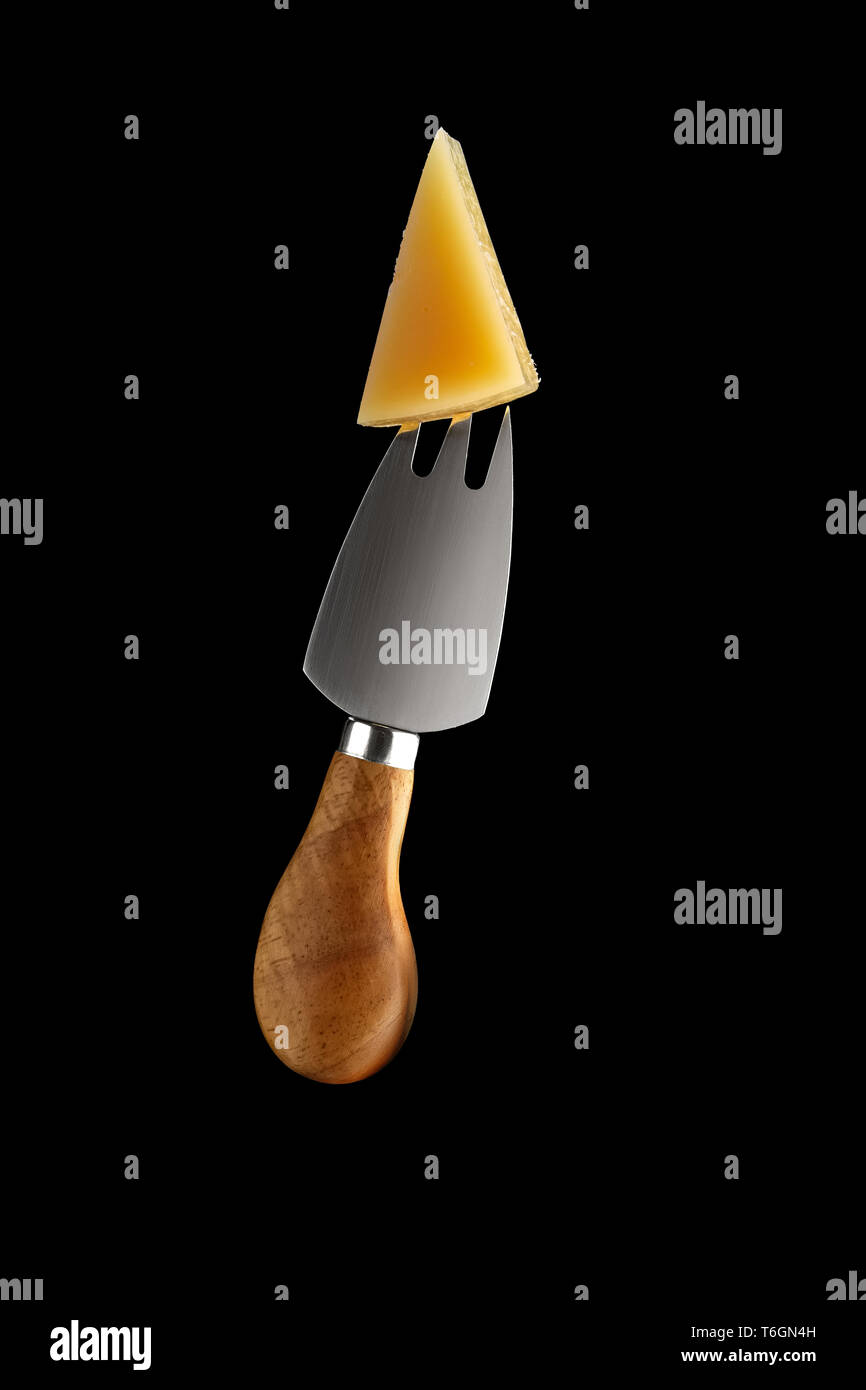 Cheese fork with piece of parmesan on it isolated on black background ...