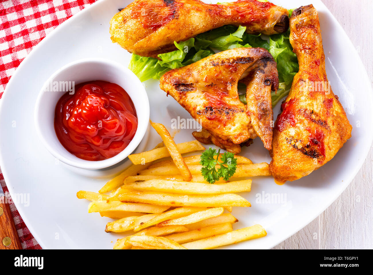 Grilled chicken wings,legs,chips and vegetables Stock Photo - Alamy