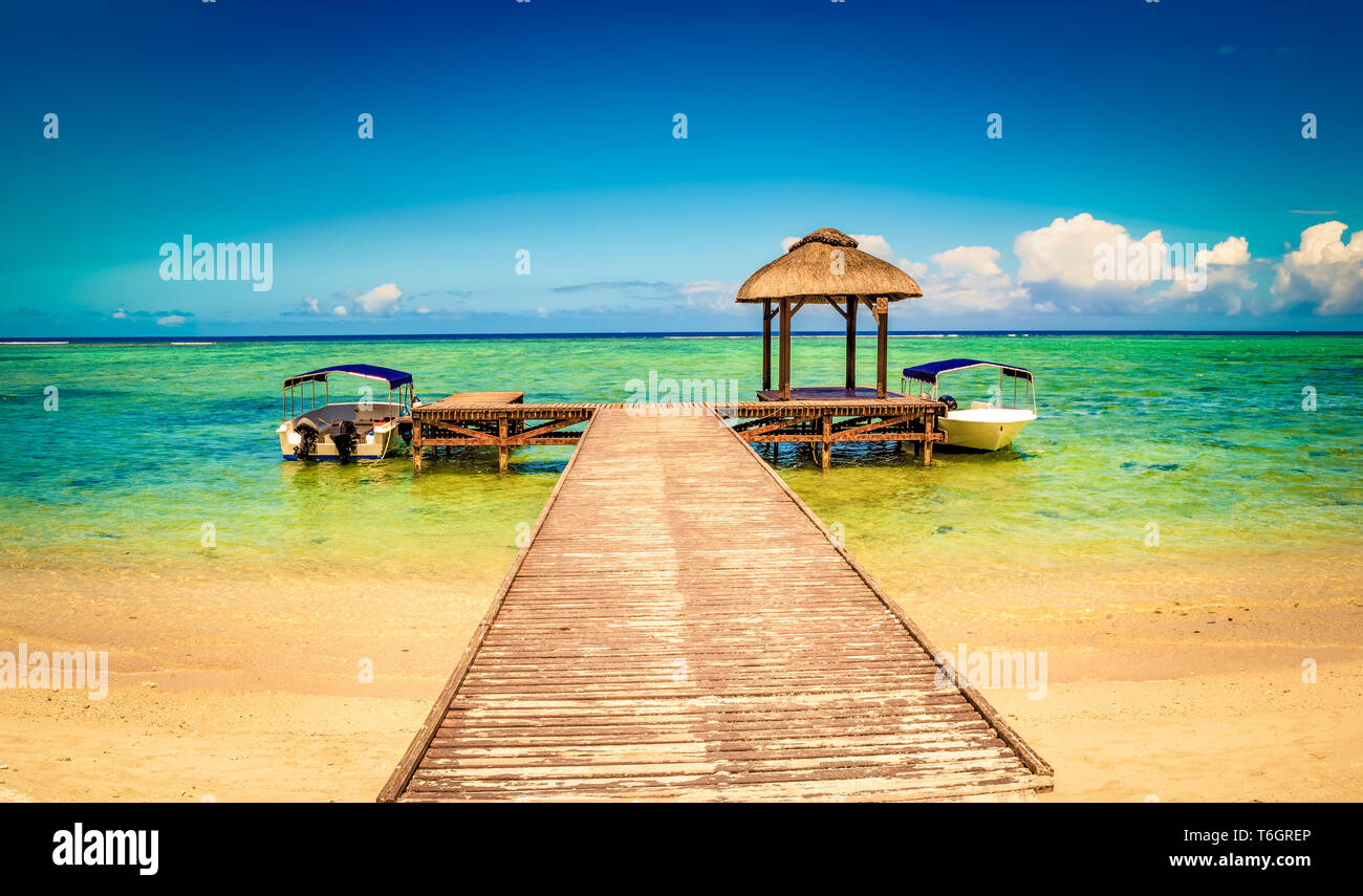 Sandy tropical beach. Jetty on the foreground Stock Photo - Alamy