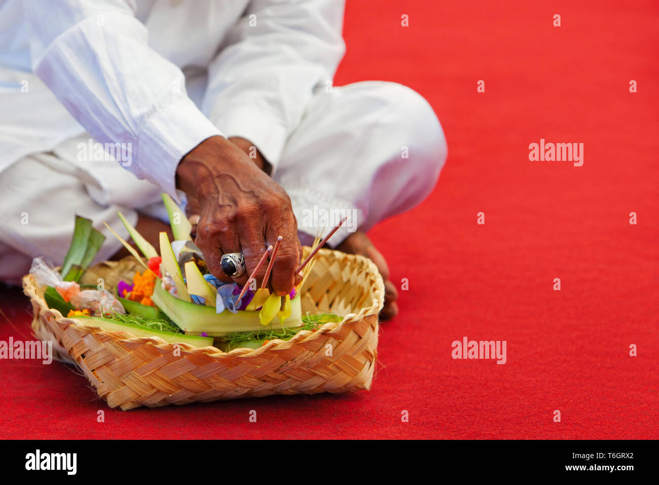 In hindu temple priest mangku praying and making offerings ritual ...