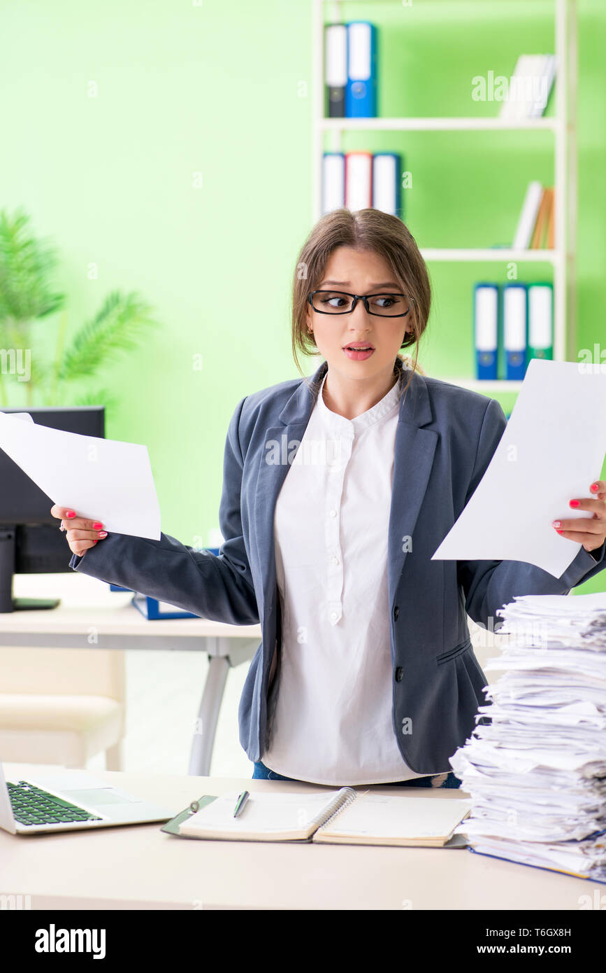 Young female employee very busy with ongoing paperwork Stock Photo - Alamy