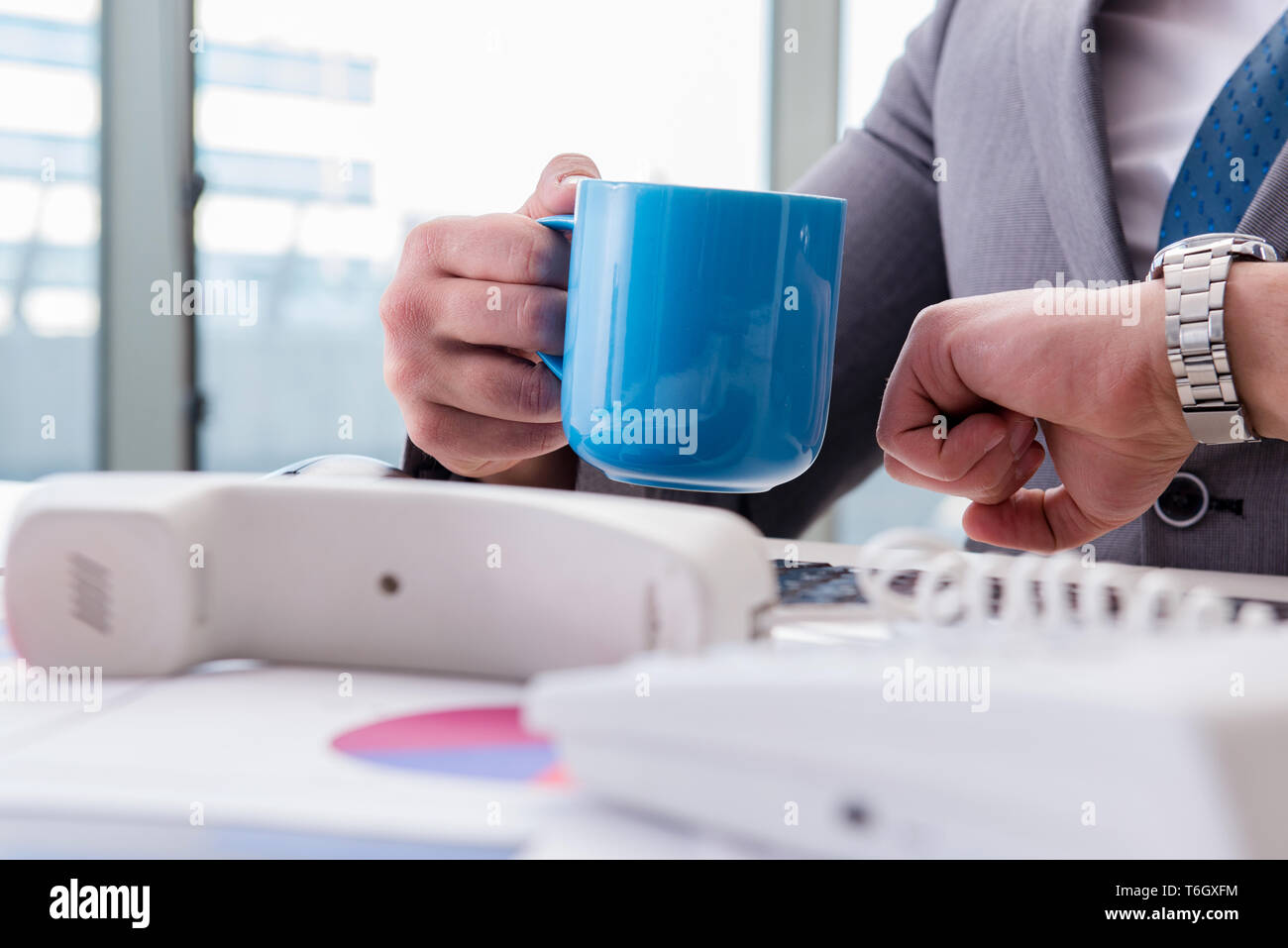 Businessman drinking coffee in the office Stock Photo - Alamy