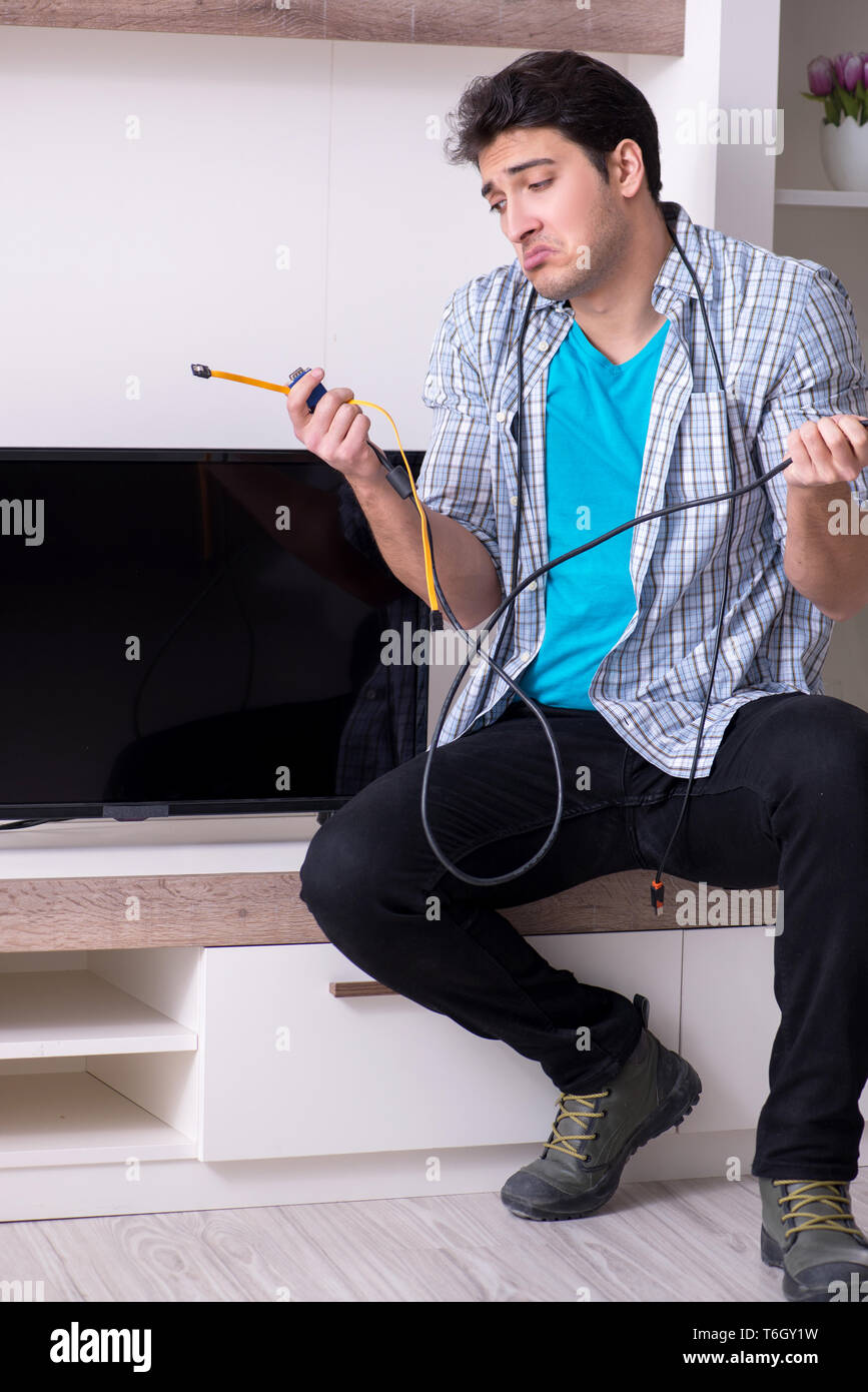 Man trying to fix broken tv Stock Photo - Alamy