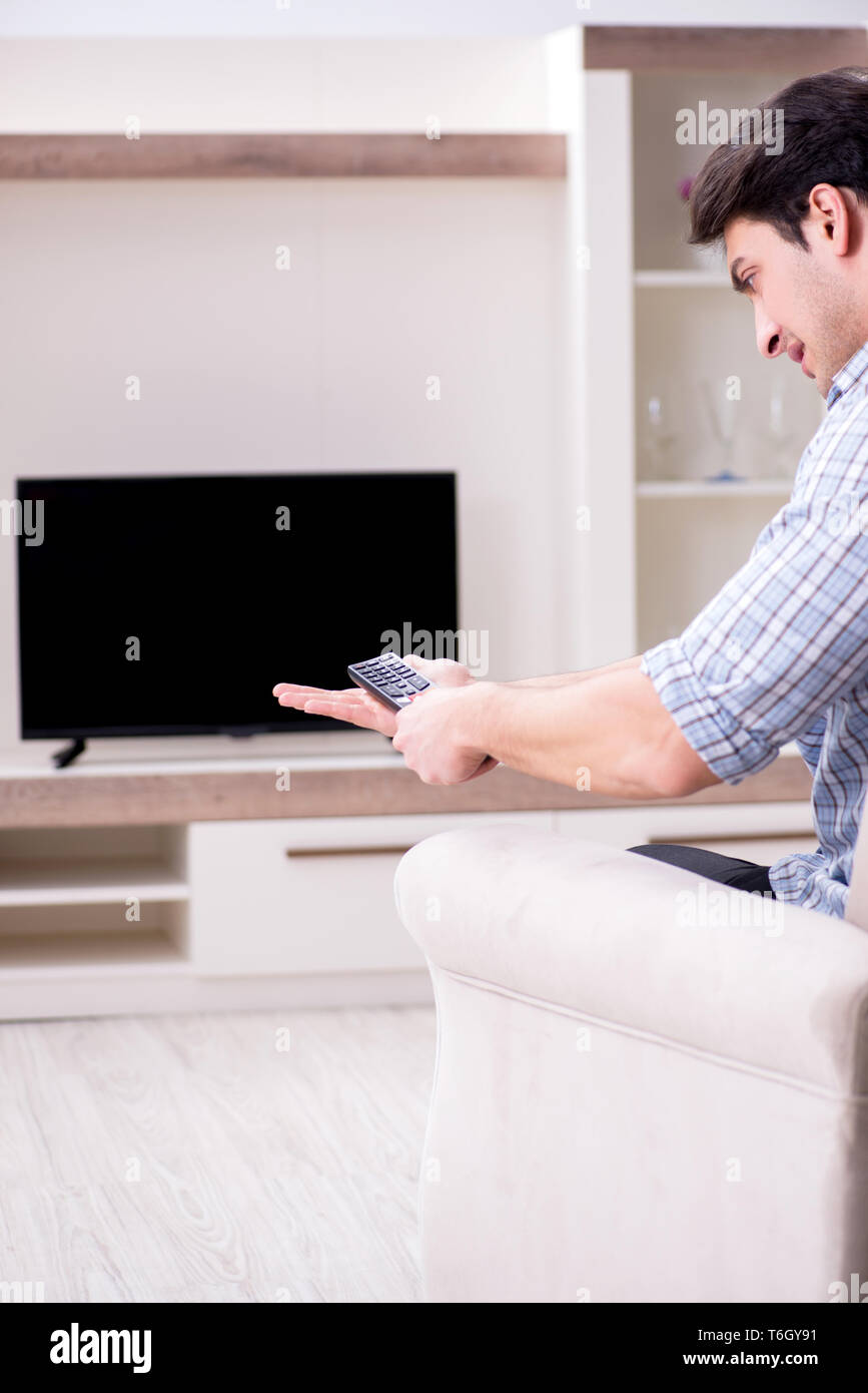 Young man watching tv at home Stock Photo - Alamy