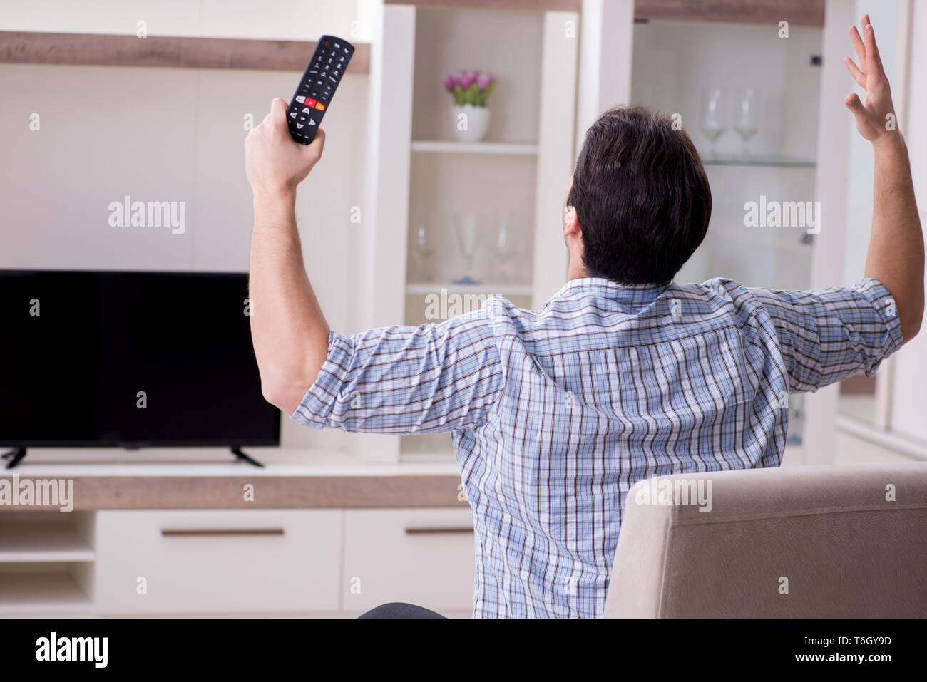 Young man watching tv at home Stock Photo - Alamy