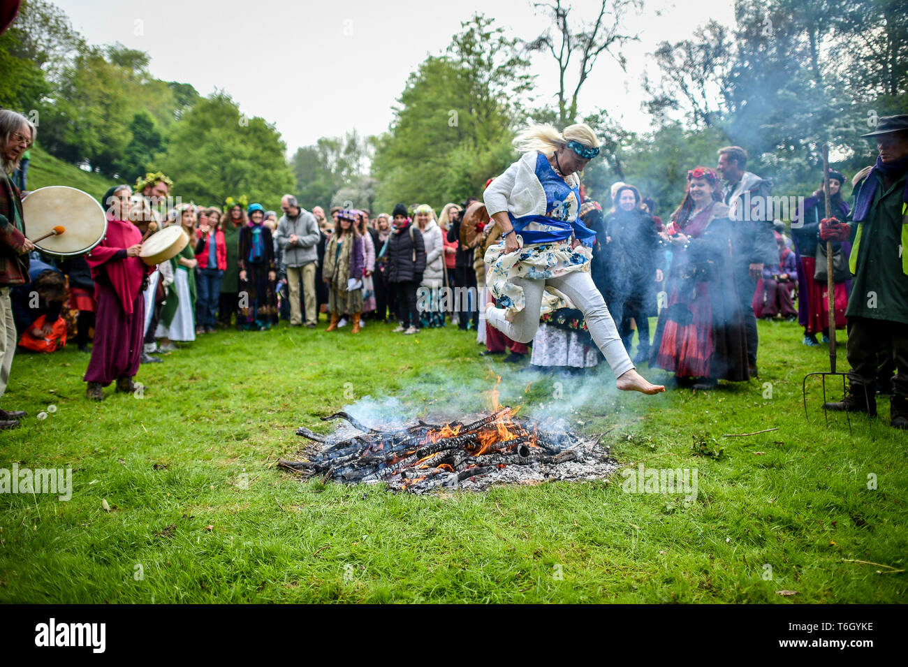 A woman leaps over the fire during the Beltane celebrations at ...