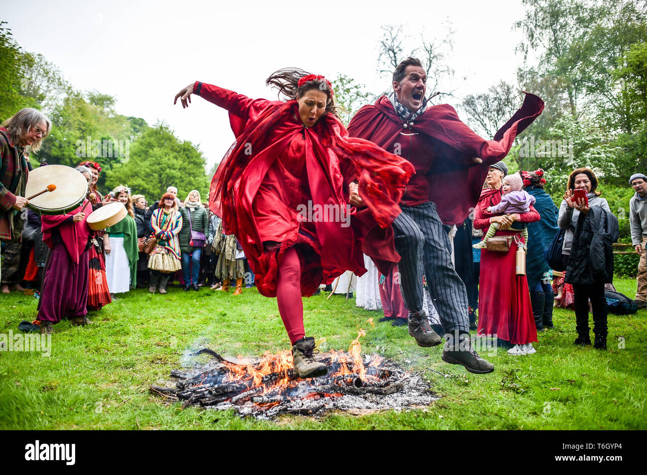 A couple jump over the fire during the Beltane celebrations at ...