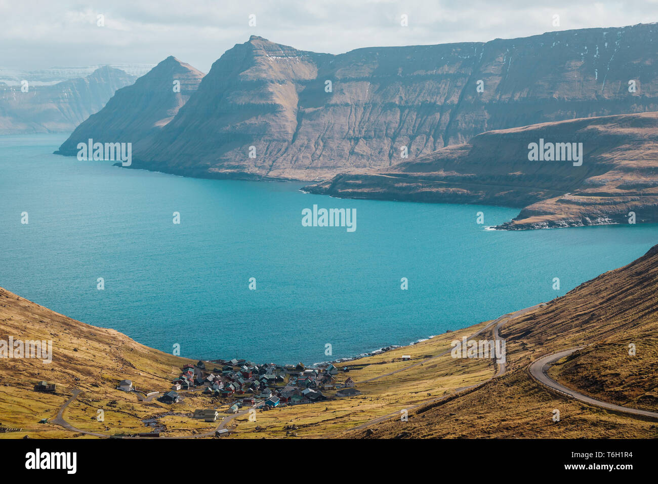 The small village of Funningur as seen from above with huge mountains ...