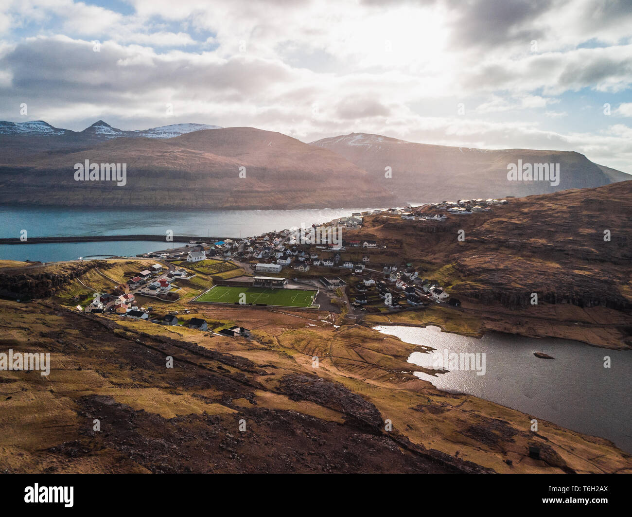 Aerial view of the village Eiði with snow-covered mountain range ...
