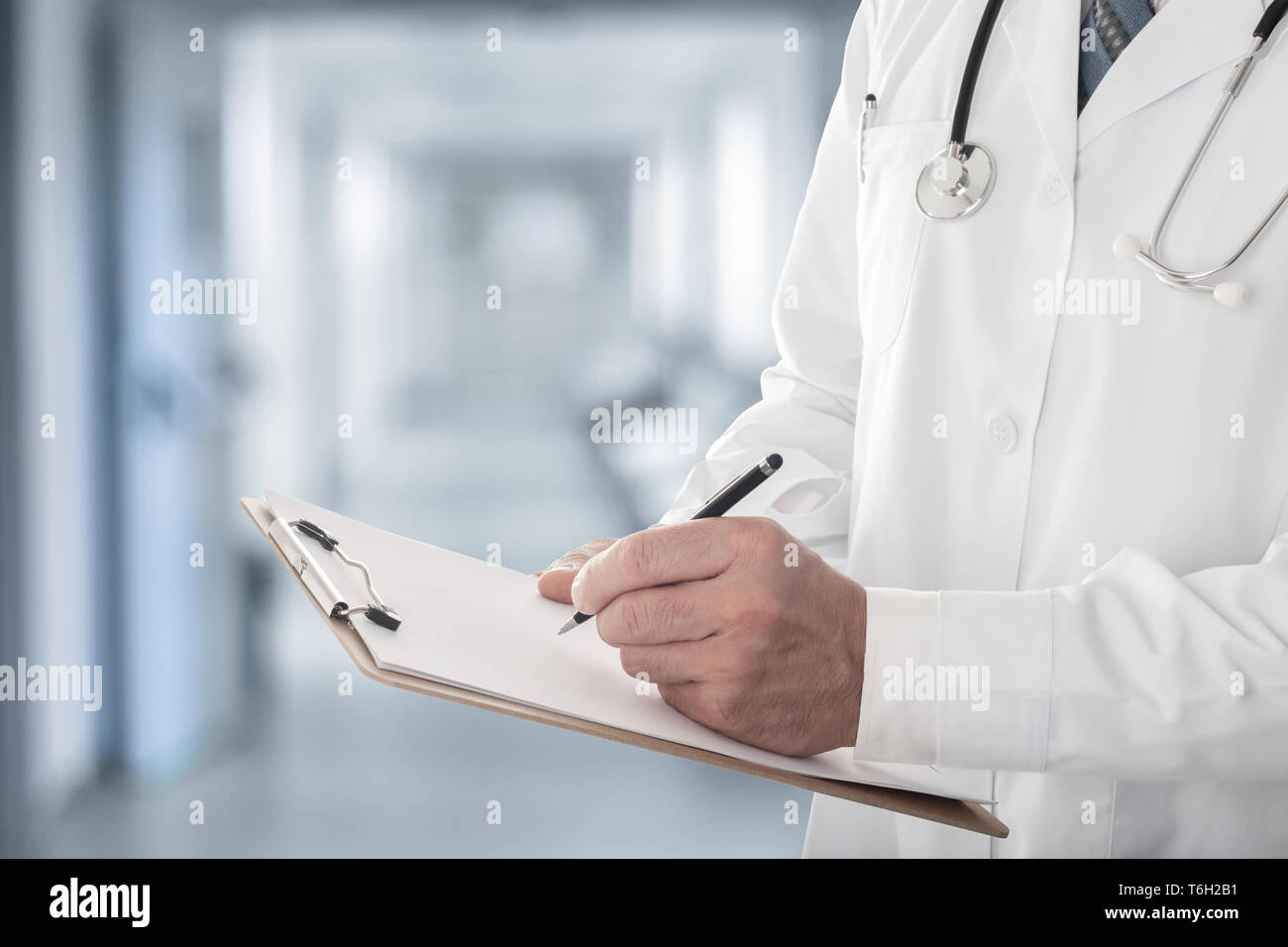 Doctor filling up medical form Stock Photo - Alamy