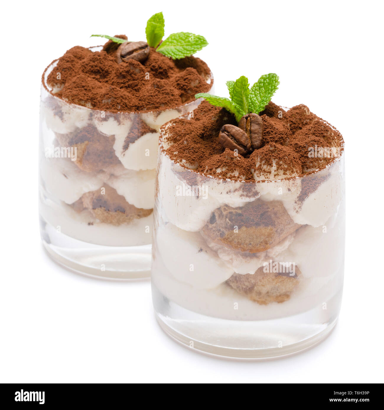 two portions Classic tiramisu dessert in a glass isolated on a white ...