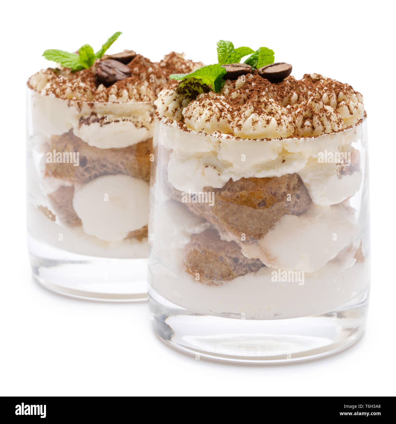 two portions Classic tiramisu dessert in a glass isolated on a white ...