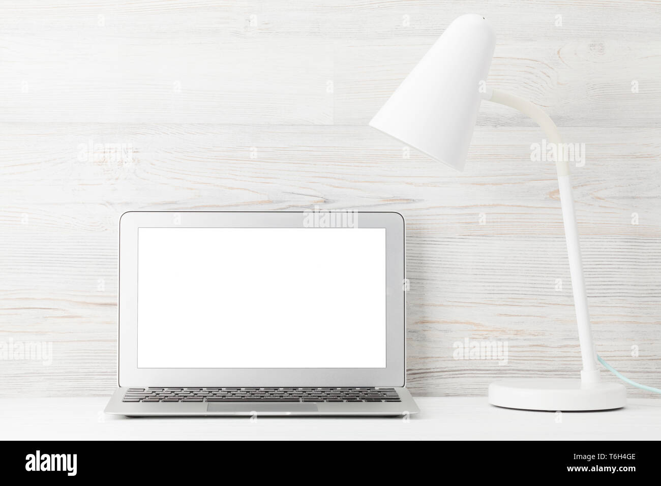 Home office workplace with blank white screen laptop computer. With ...