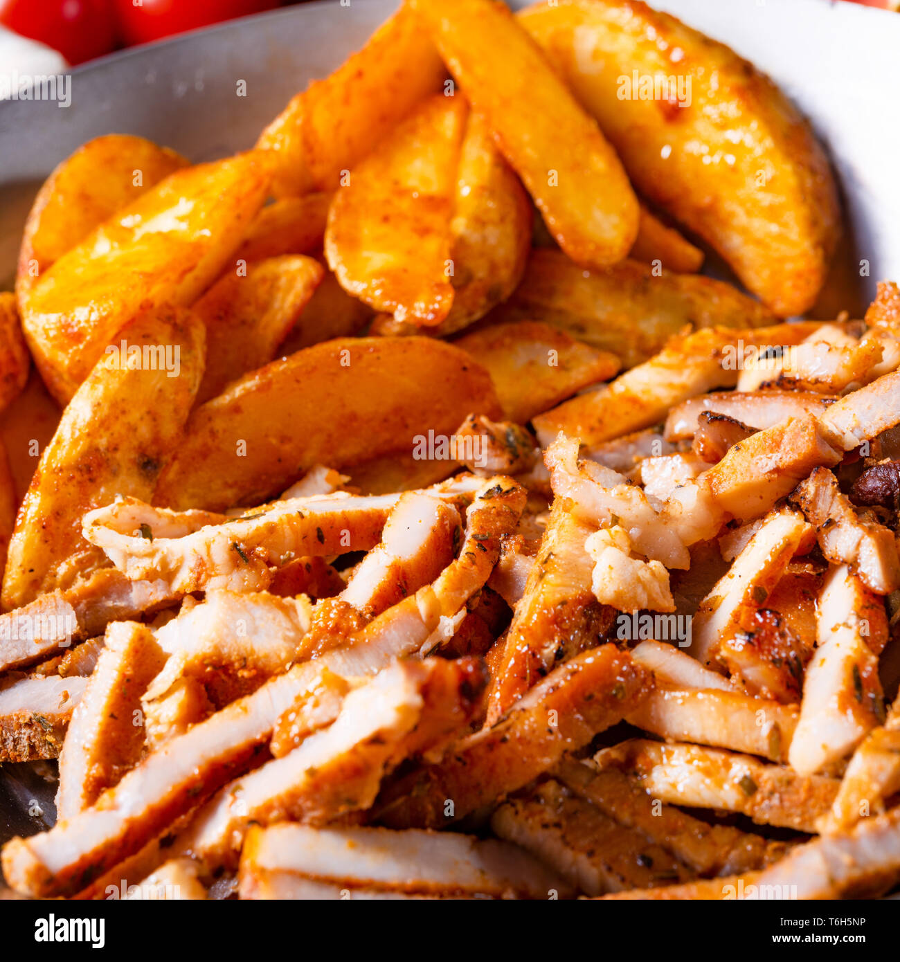 Rustic gyros plate it green salad and potato wedges Stock Photo - Alamy