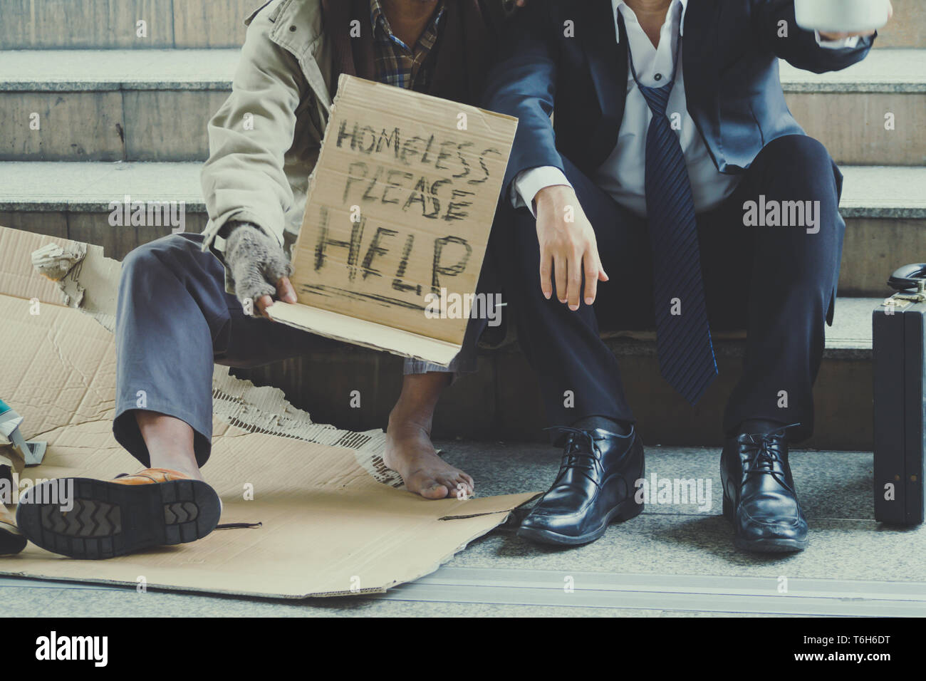 Man in need. Unhappy homeless man and businessman is holding hands to ...
