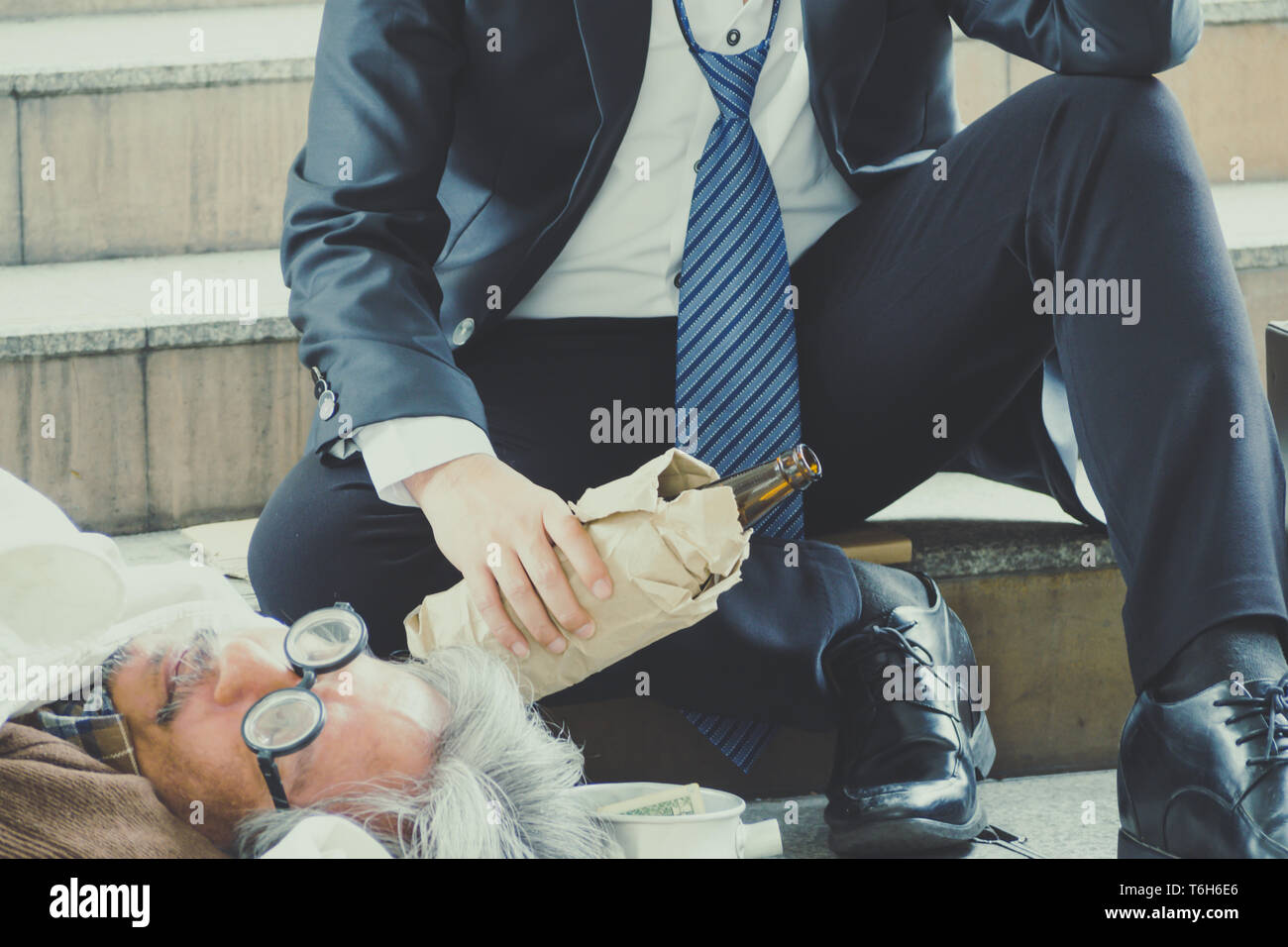 Man in need. Unhappy homeless man and businessman is holding hands to ...