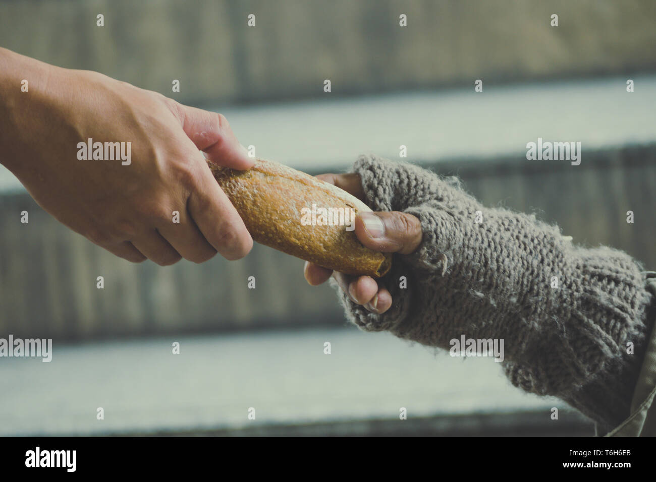 Businessman is giving the bread to homeless man Stock Photo - Alamy