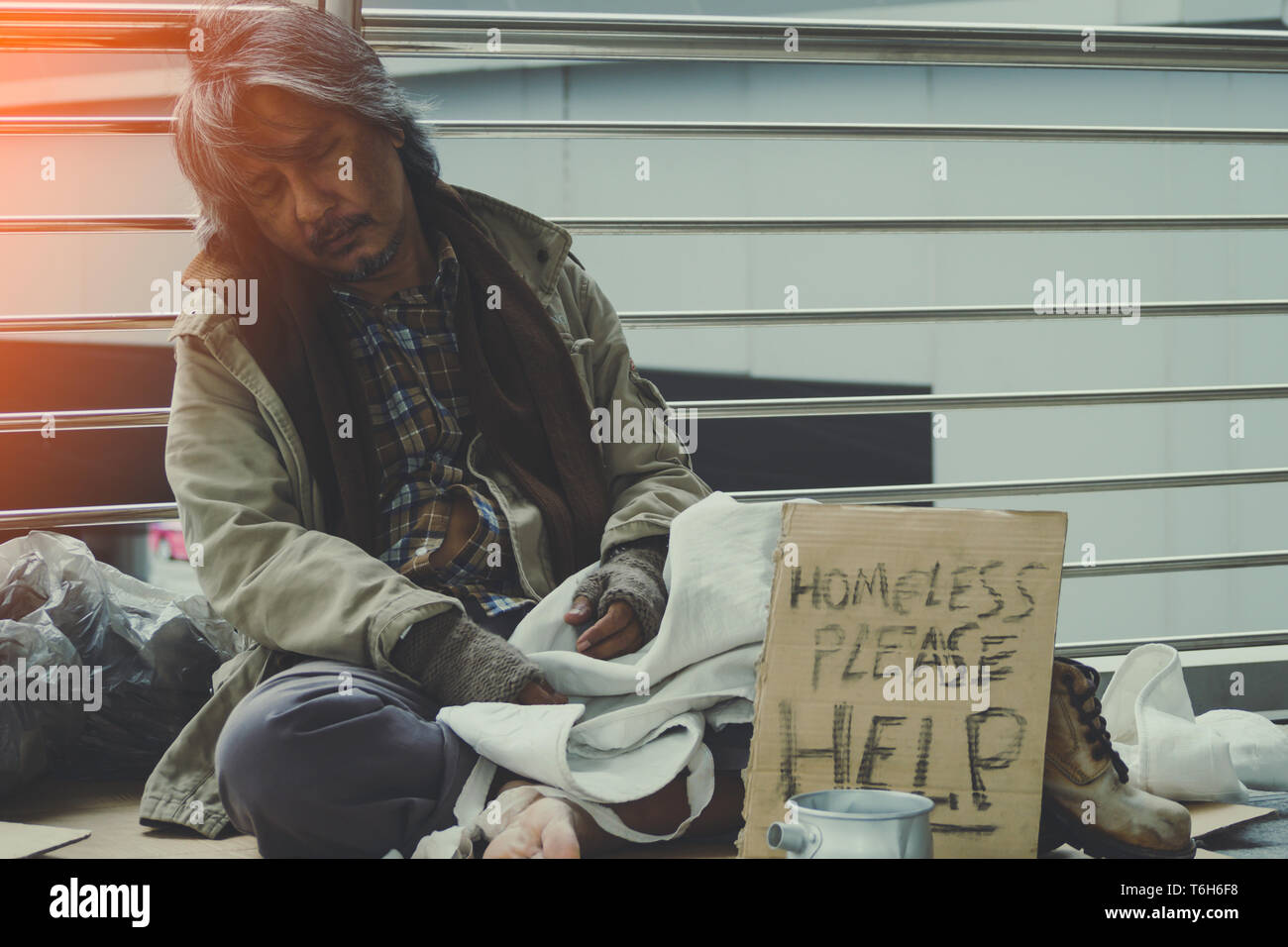 The homeless man was so tired he fell asleep sitting in his area Stock ...