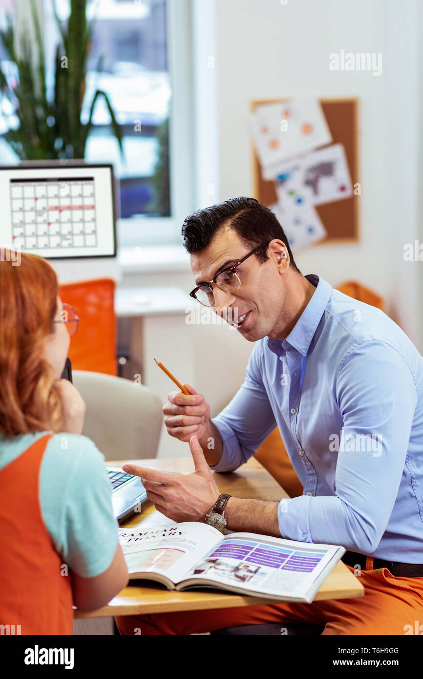 Joyful nice teacher talking with his student Stock Photo - Alamy