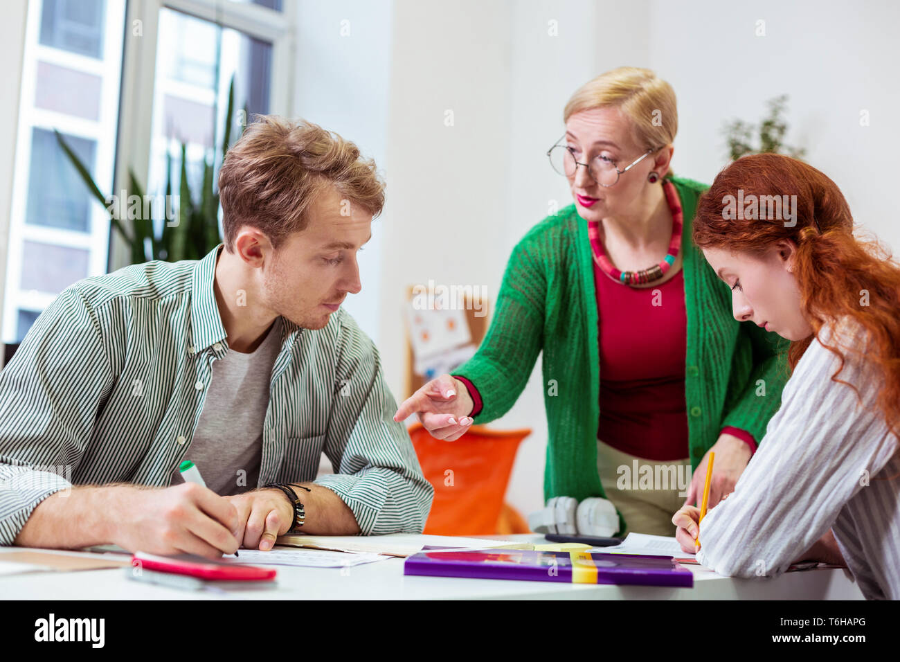 Nice pleasant woman asking a question to her student Stock Photo - Alamy