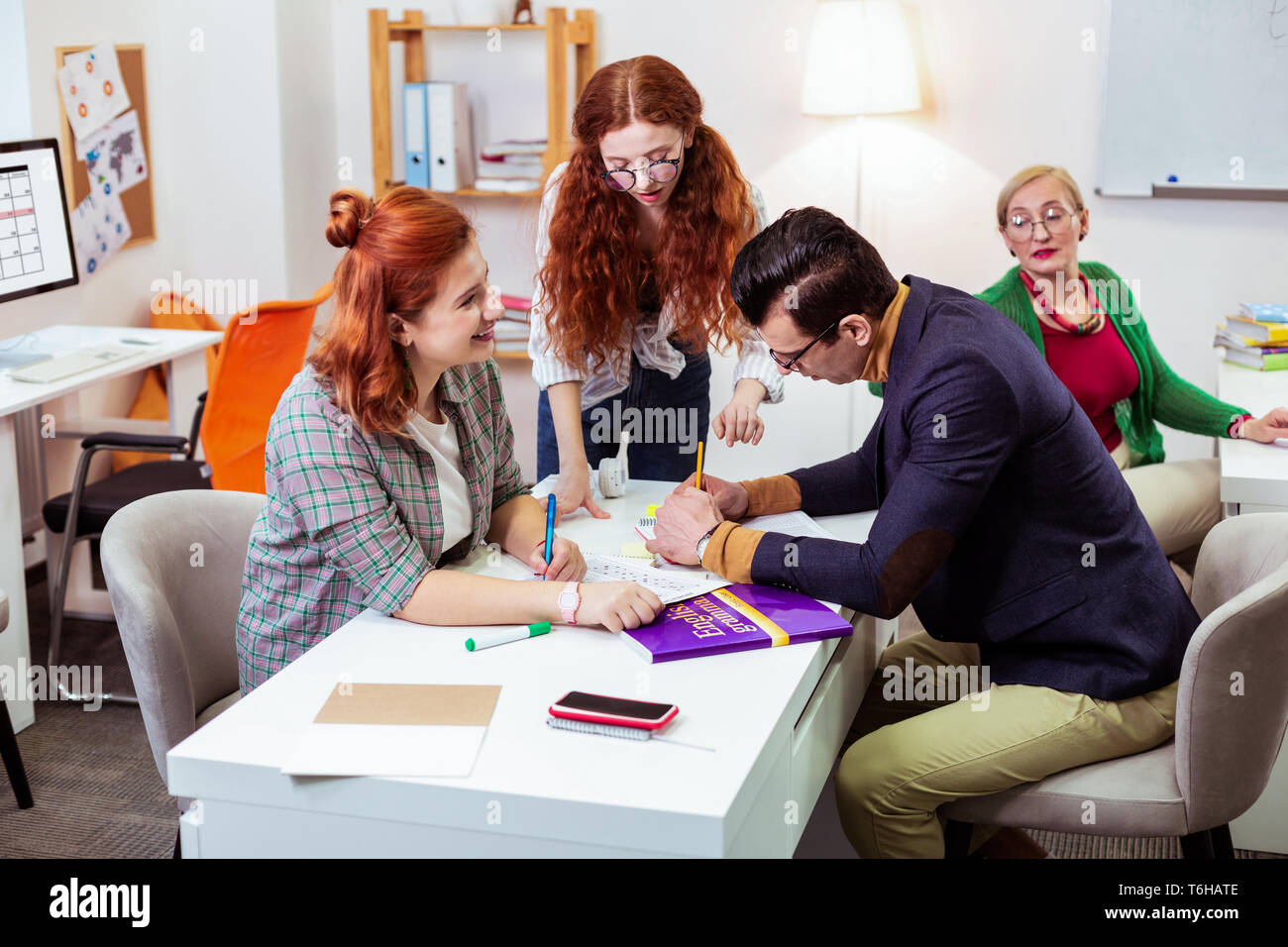 Joyful smart young people doing their tasks Stock Photo - Alamy