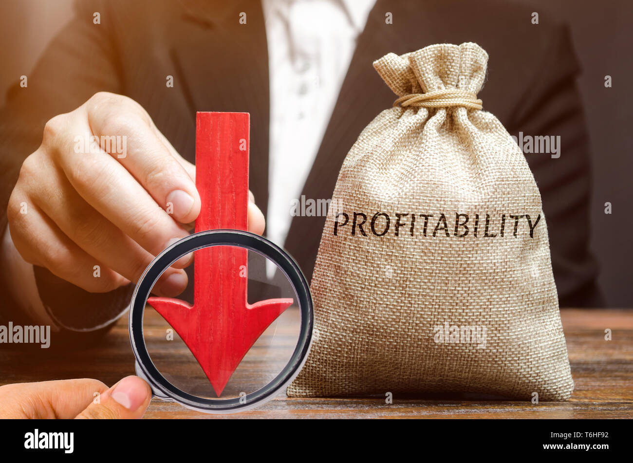 Bag with the word Profitability and a down arrow with a businessman ...