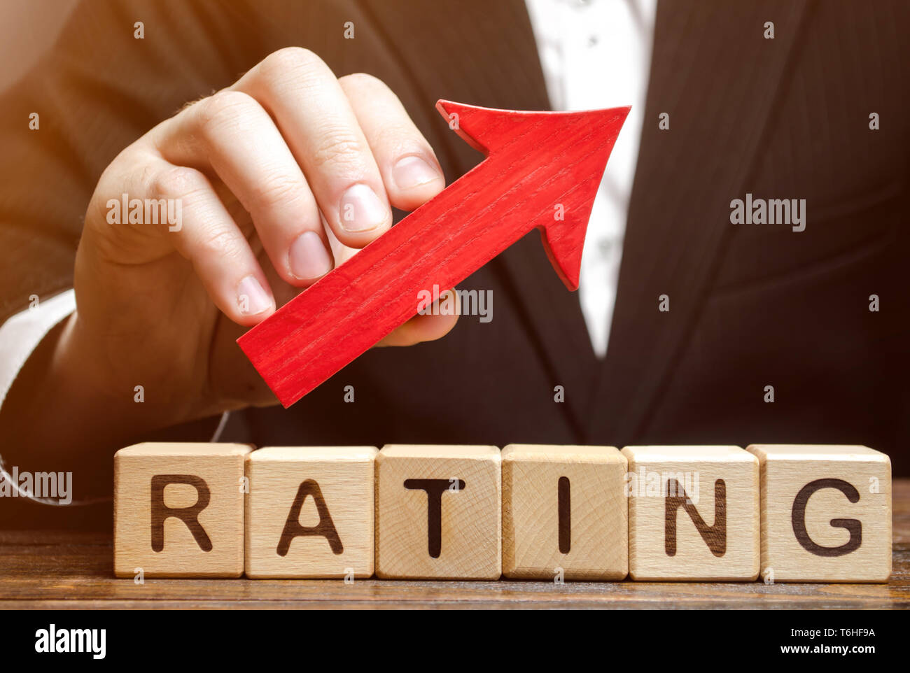Wooden blocks with the word Rating and the up arrow in the hands of the ...