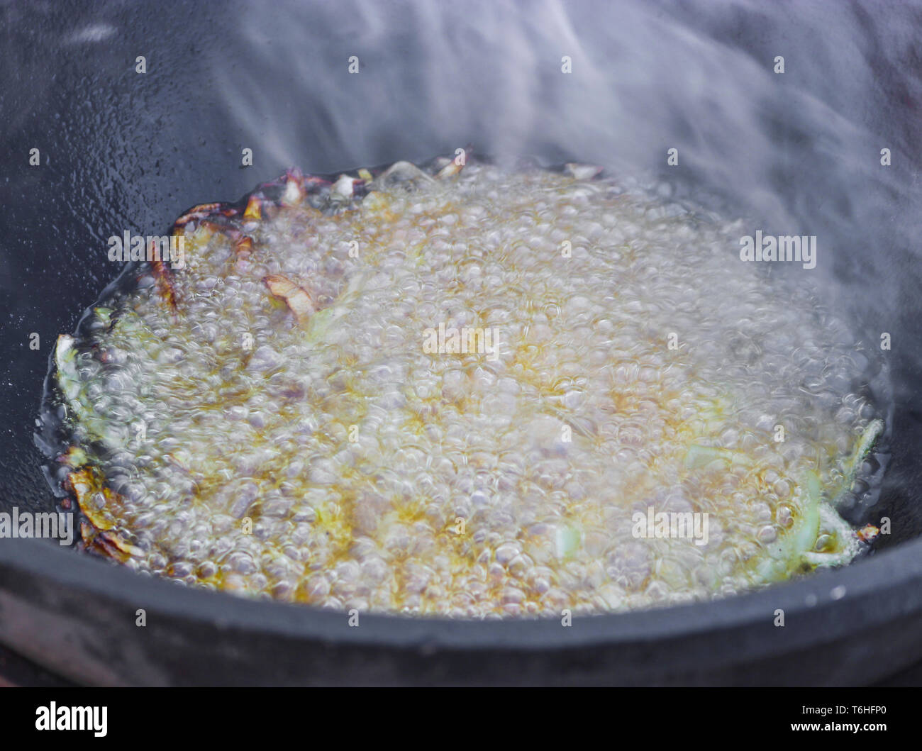 Cauldron with boiling oil on the stove - fried onions for pilaf Stock ...