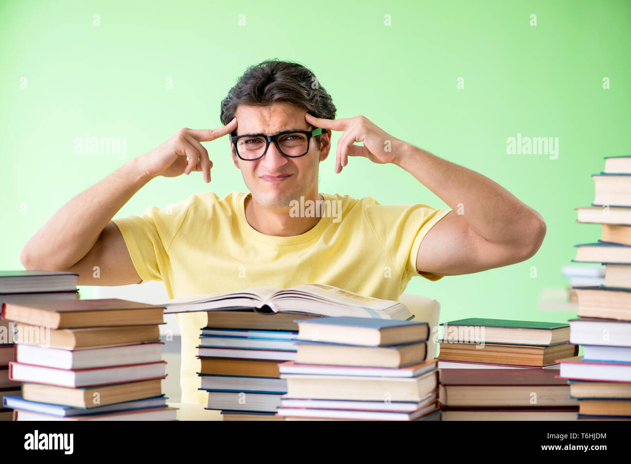 Student with too many books to read before exam Stock Photo - Alamy