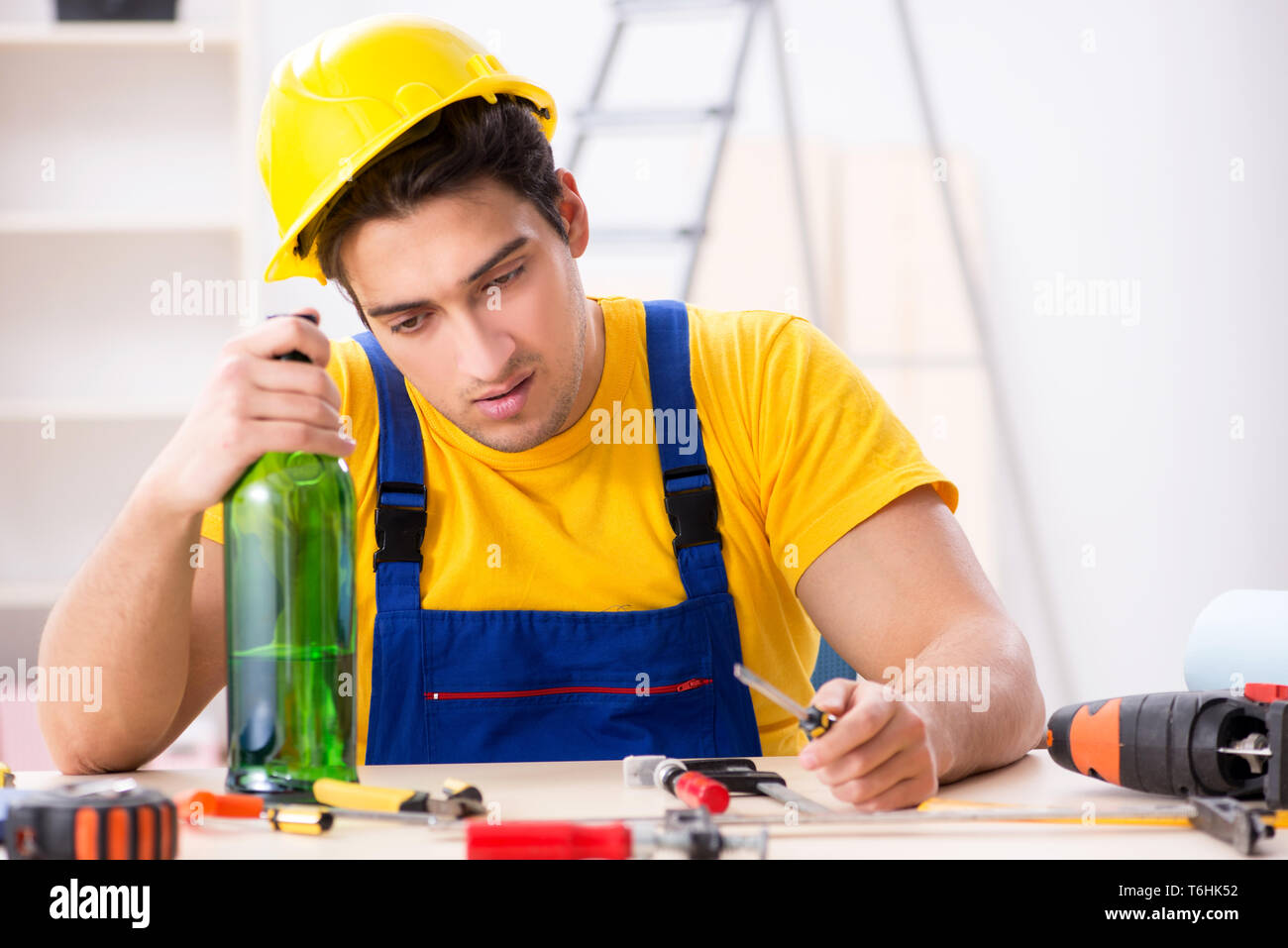 Drunk engineer working in the workshop Stock Photo - Alamy