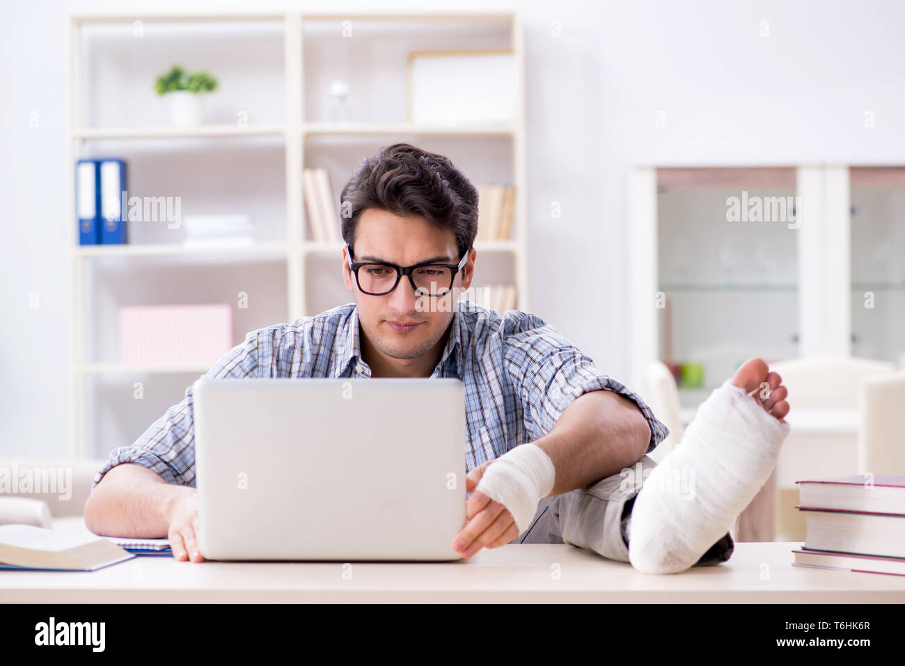 Freelancer with foot injury working from home Stock Photo - Alamy
