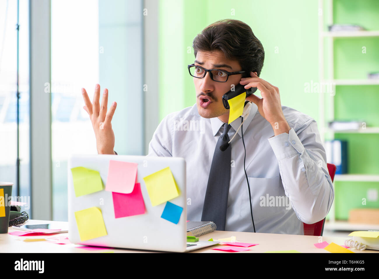 Young help desk operator working in office with many conflicting Stock ...