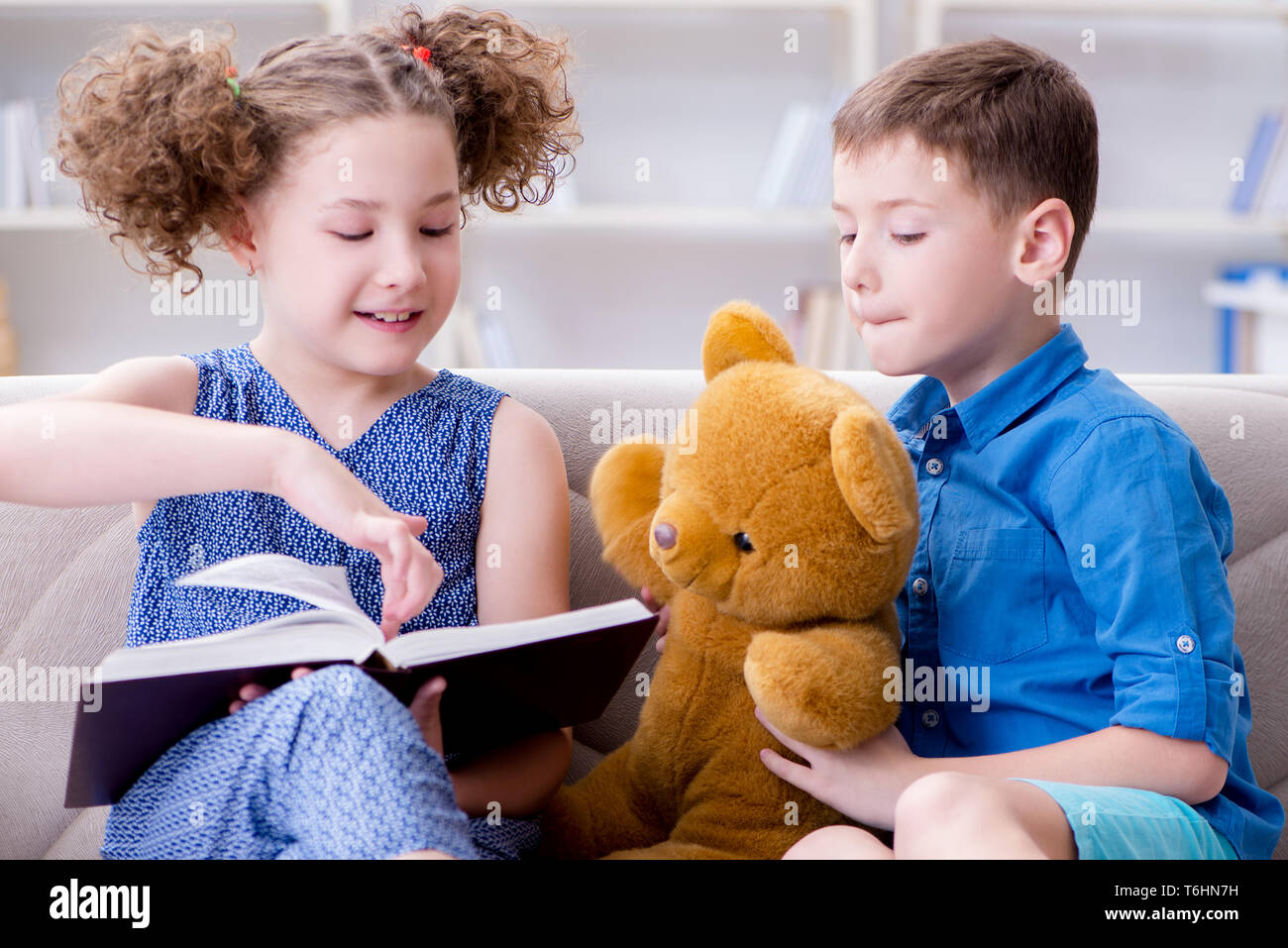 Two kids reading books at home Stock Photo - Alamy