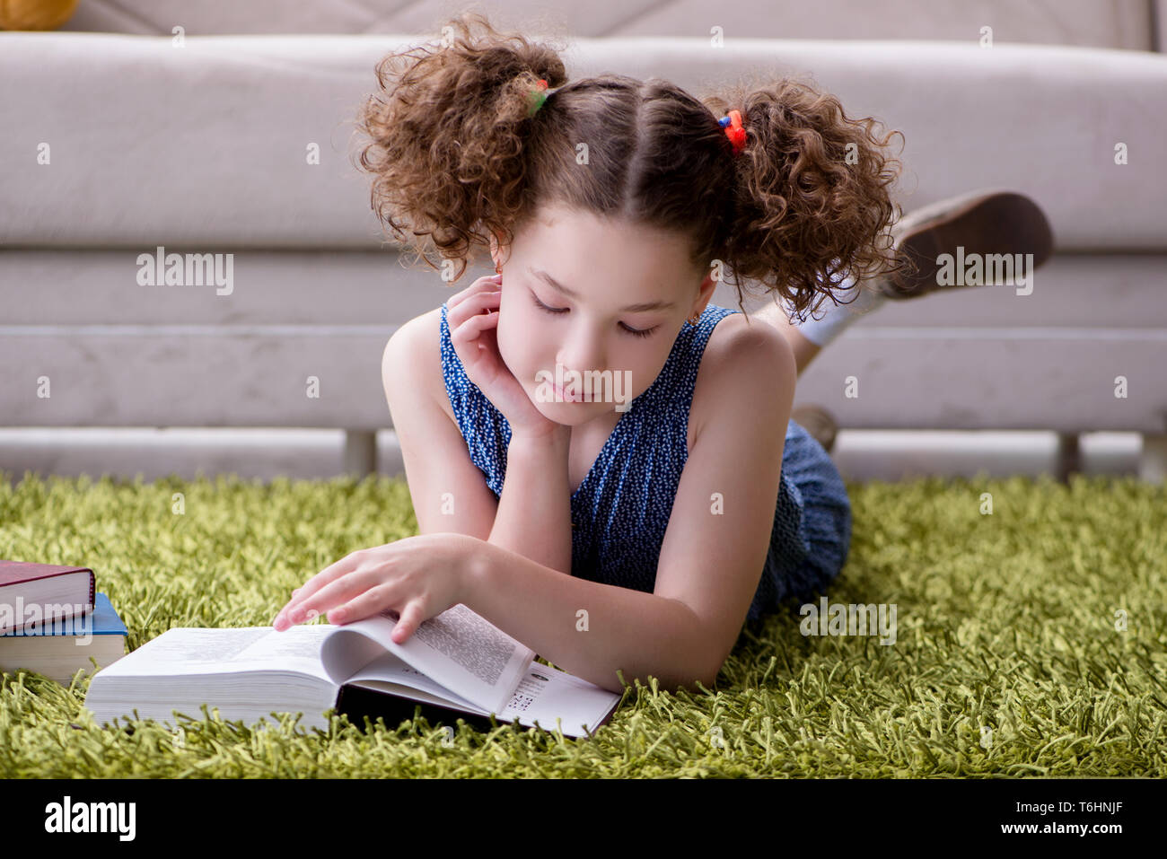 Little pretty girl reading books at home Stock Photo - Alamy