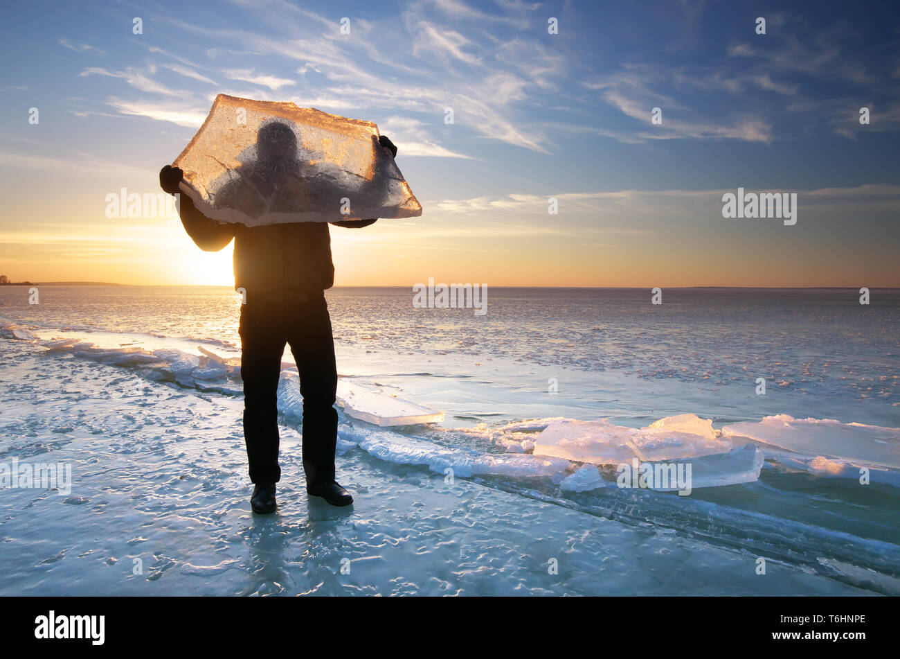 Man and winter ice block in hand Stock Photo - Alamy
