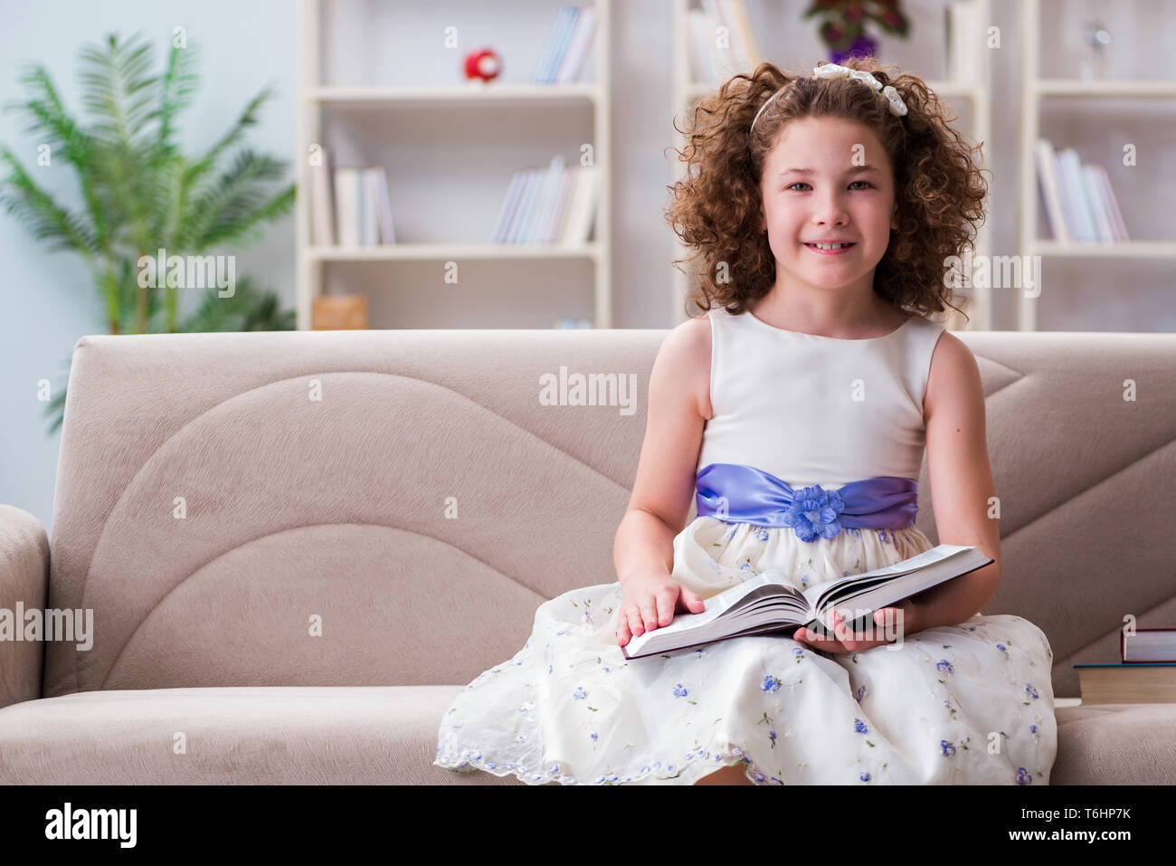 Little pretty girl reading books at home Stock Photo - Alamy