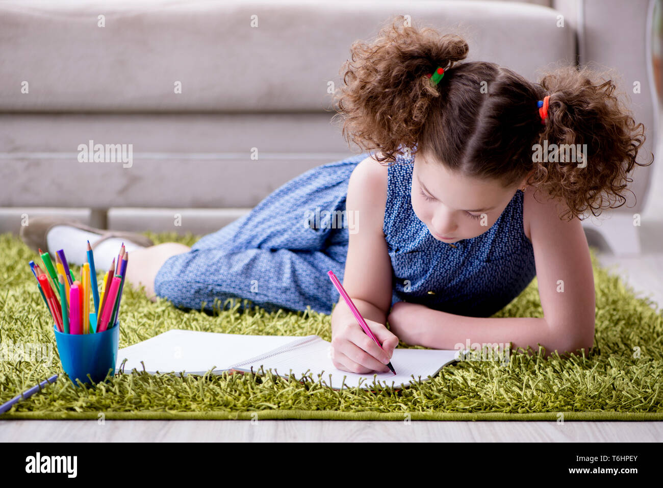 Young little girl drawing on paper with pencils Stock Photo - Alamy
