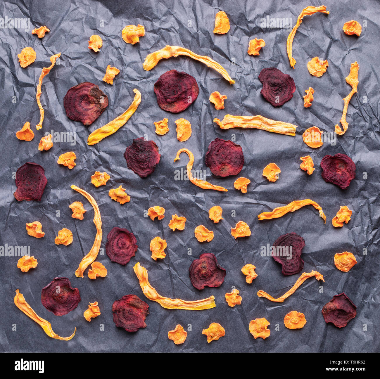 Pattern of vegetable chips on rumpled black wrapping paper Stock Photo ...