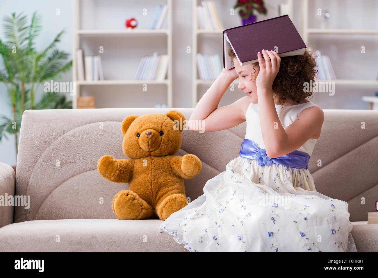 Little pretty girl reading books at home Stock Photo - Alamy