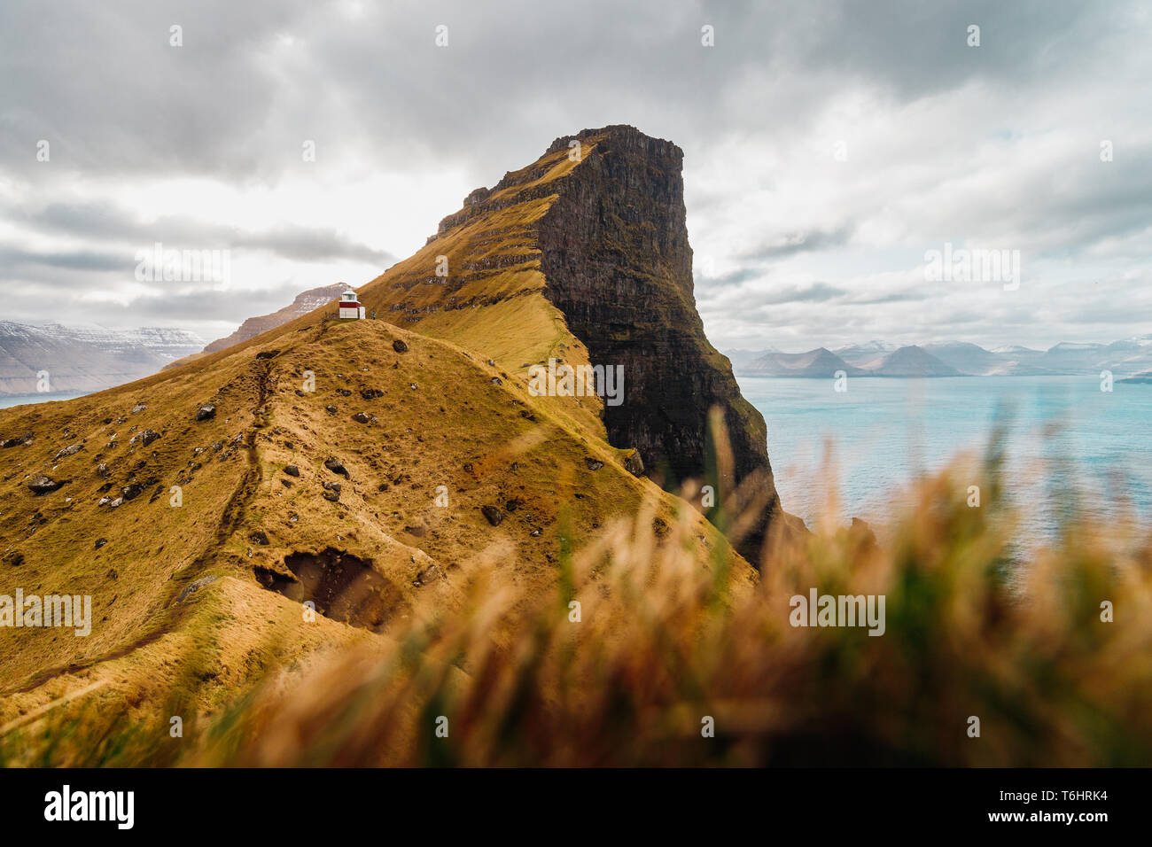 Hike towards Kallur lighthouse on Kalsoy island with high cliffs ...