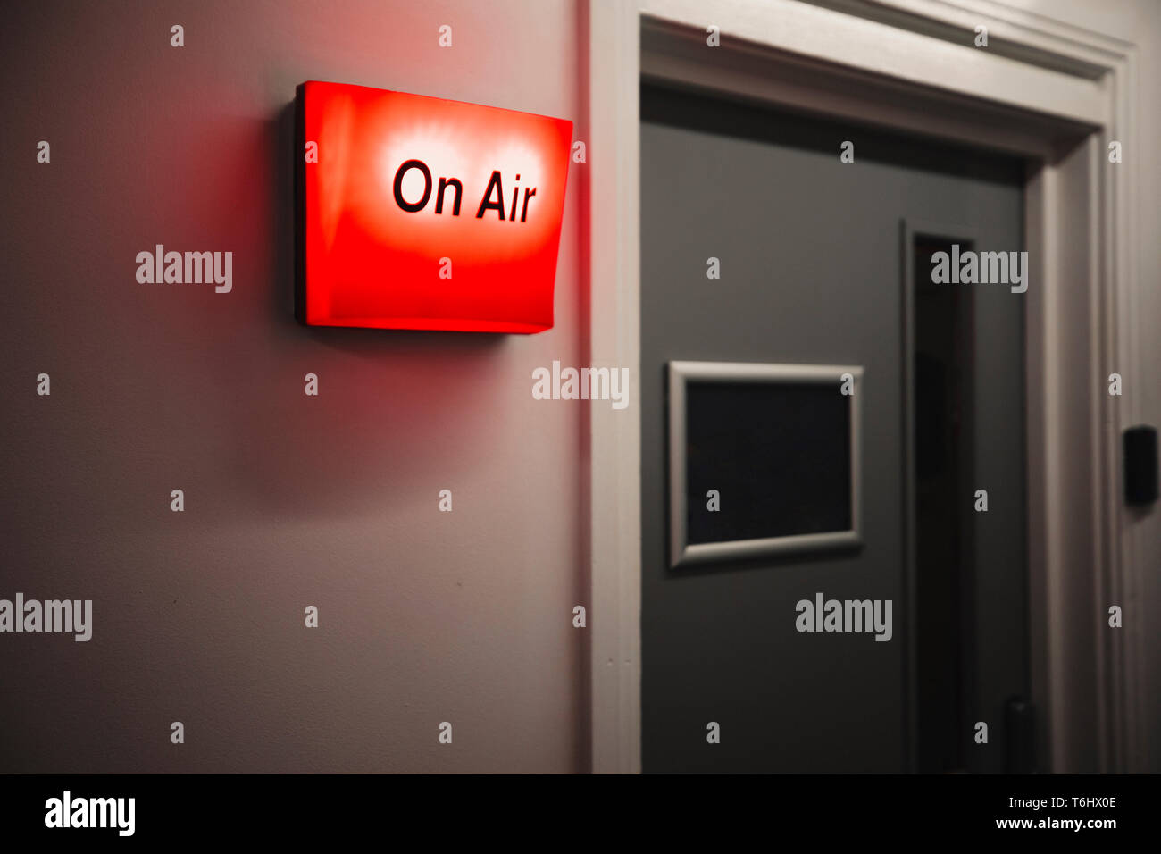A close-up shot of a red on air sign on a wall in a recording studio ...