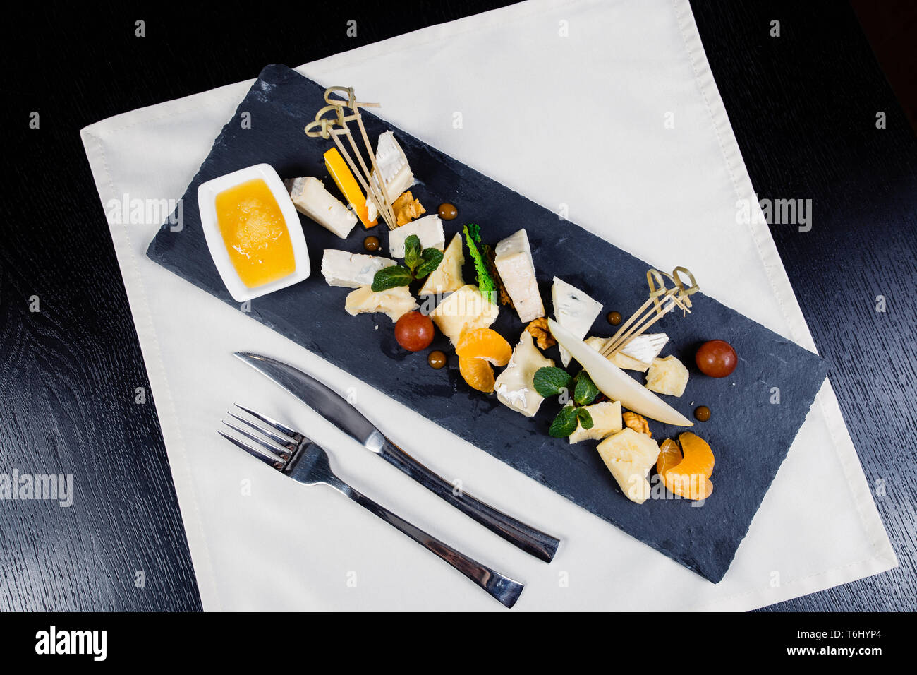 Cheese plate Assortment of various types of cheese on dark slate ...