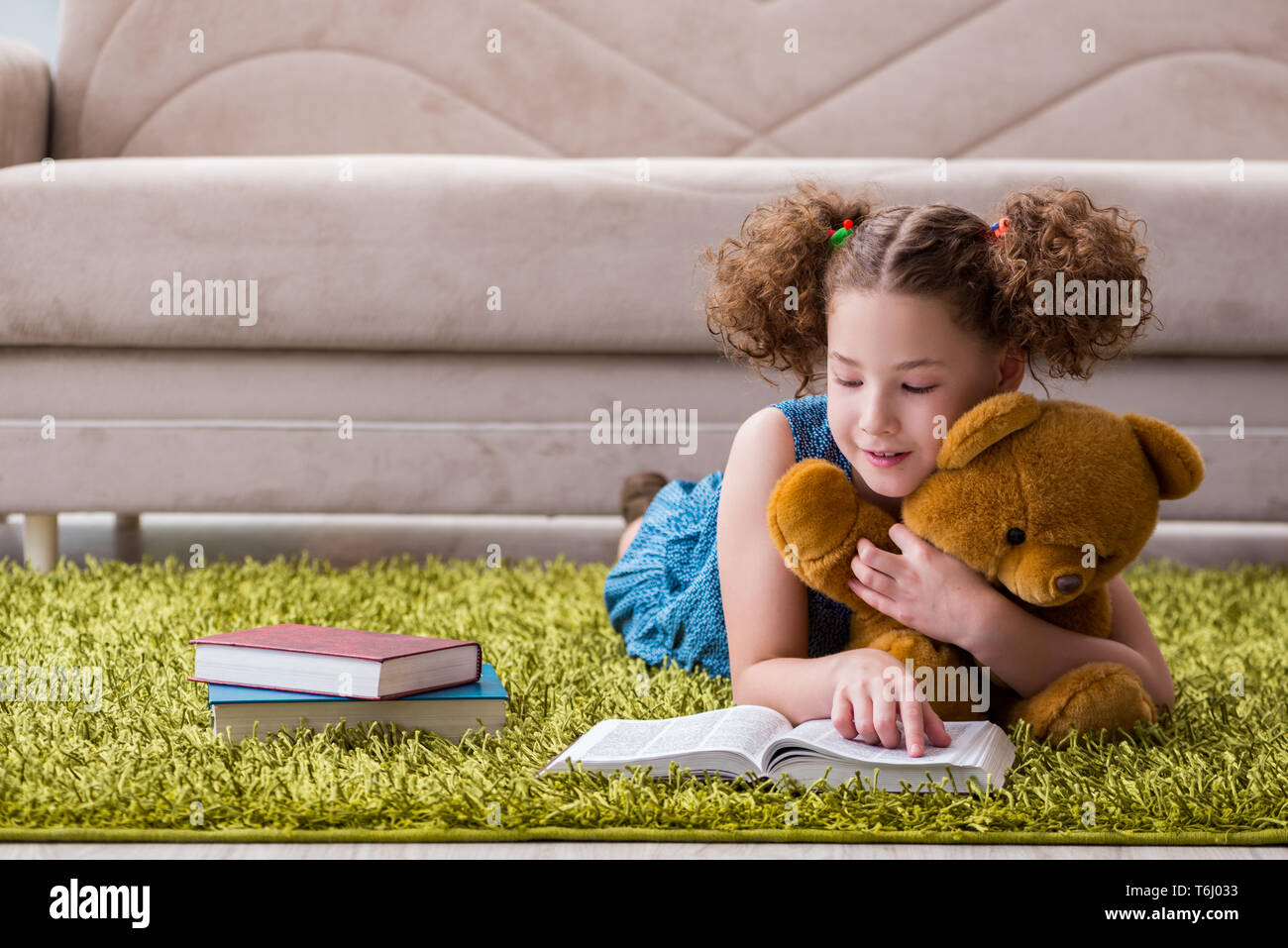 Little pretty girl reading books at home Stock Photo - Alamy