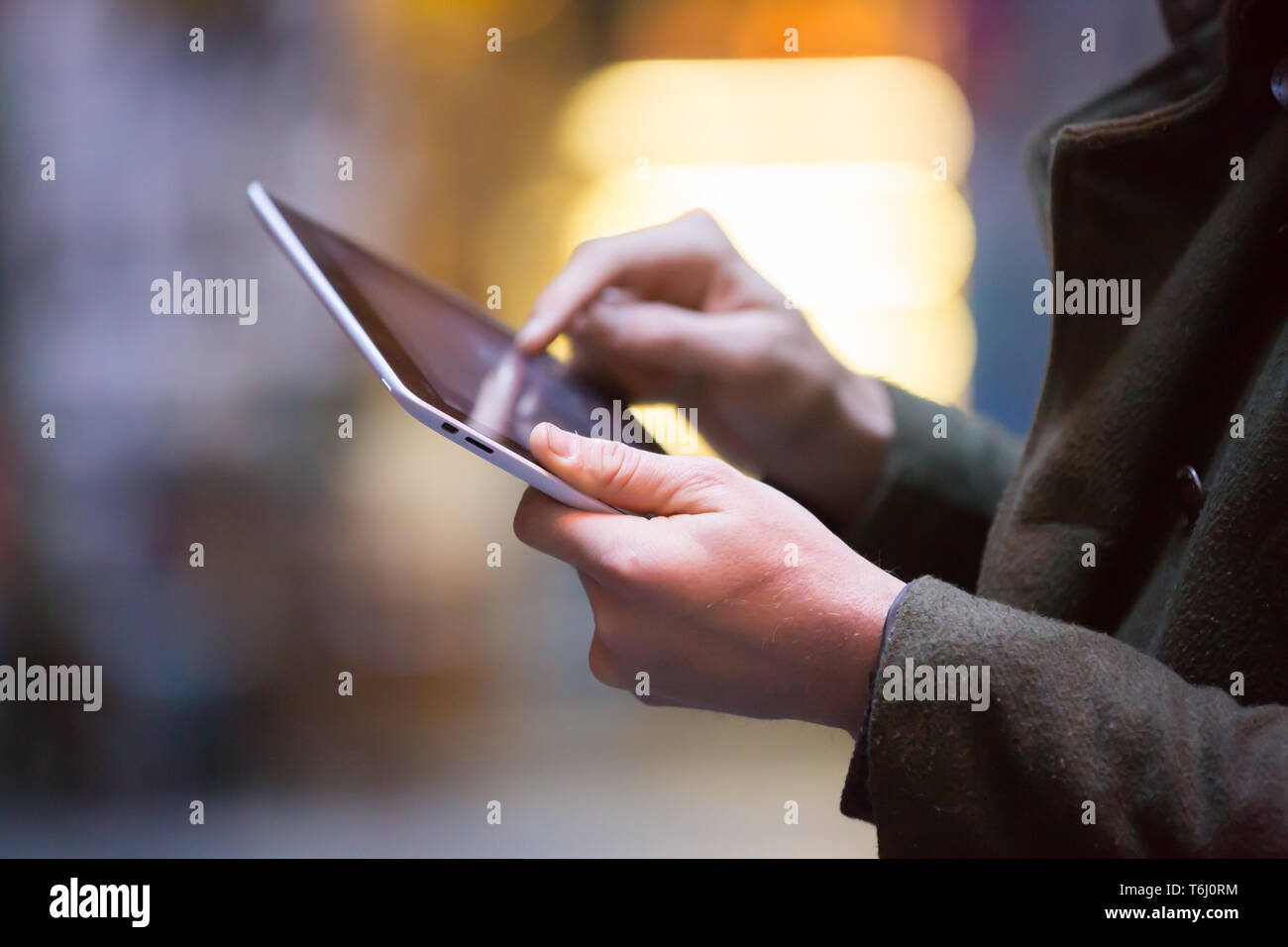 Male using a tablet outside pointing at the screen Stock Photo - Alamy